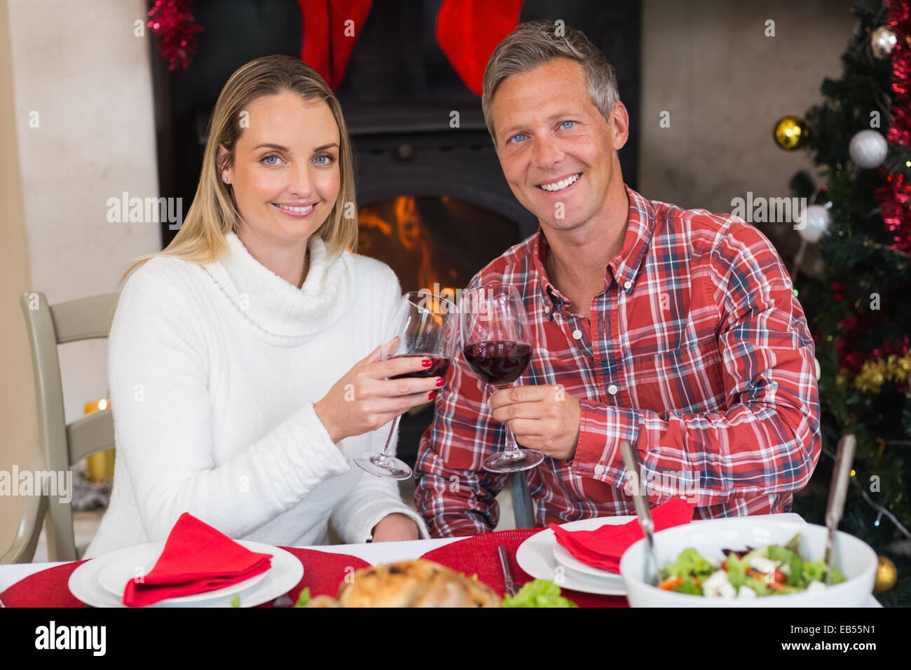 Couple toasting to the camera with red wine Stock Photo - Alamy
