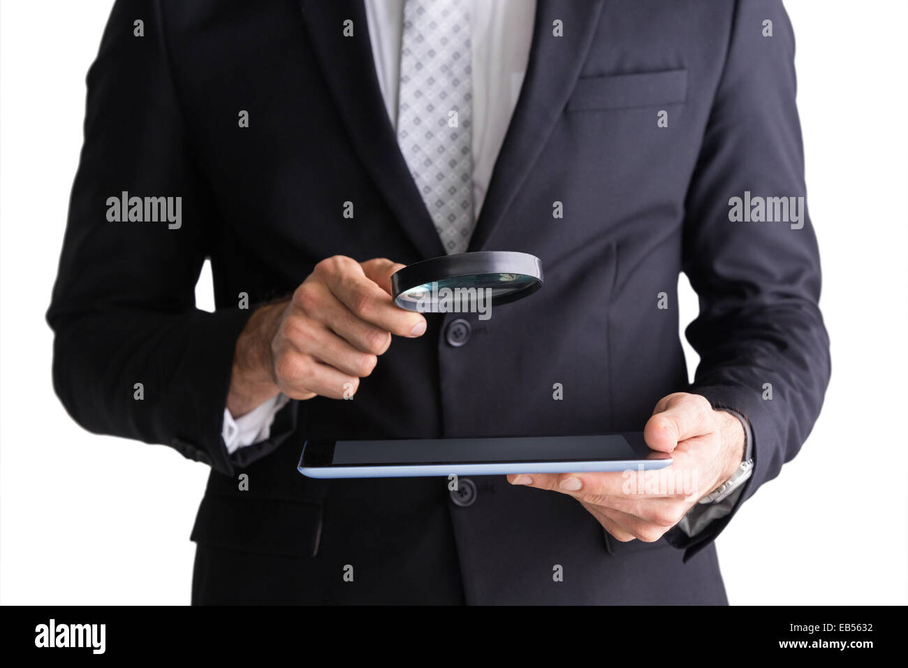 Businessman using magnifying glass and tablet Stock Photo - Alamy