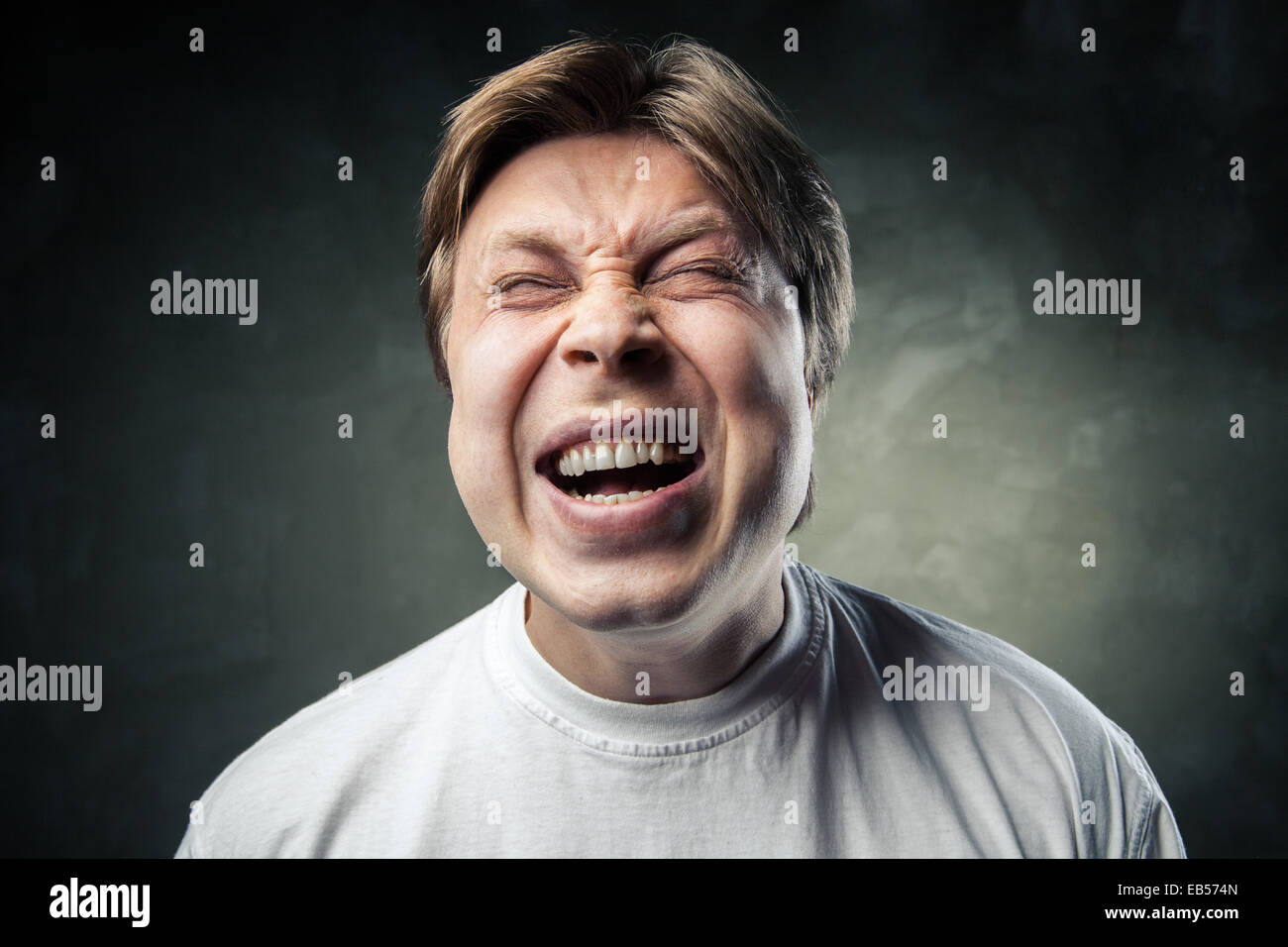 portrait of young angry man over dark grey background Stock Photo - Alamy