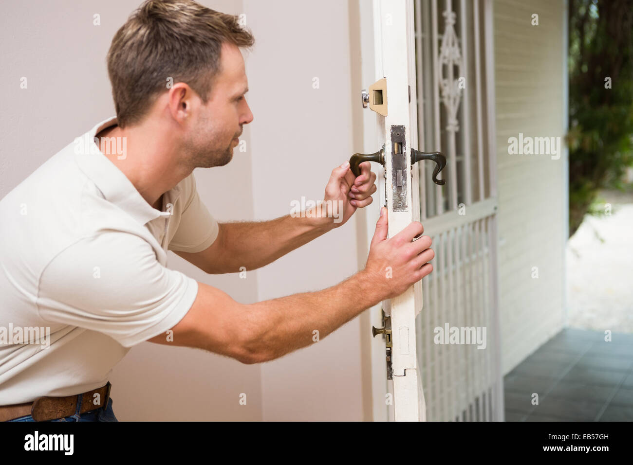 Handyman testing the door handle Stock Photo - Alamy