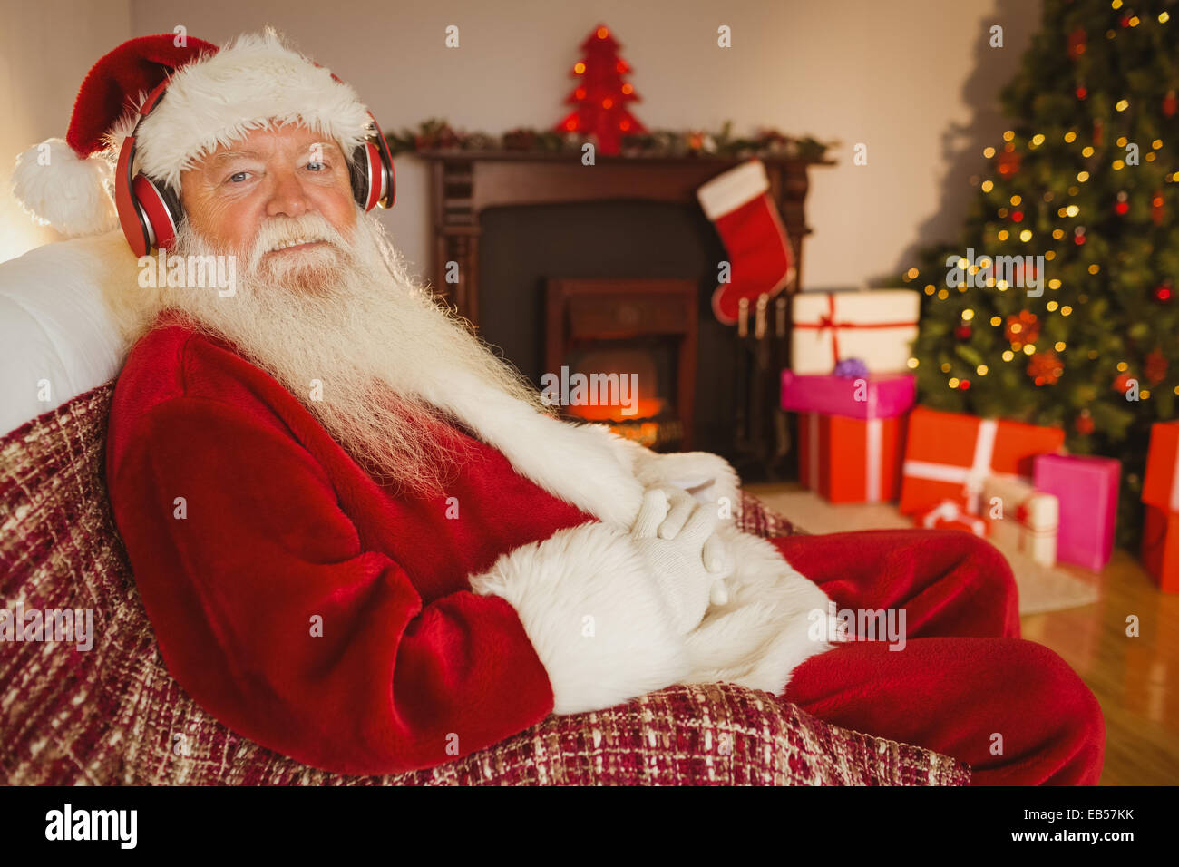 Smiling santa claus listening music Stock Photo - Alamy