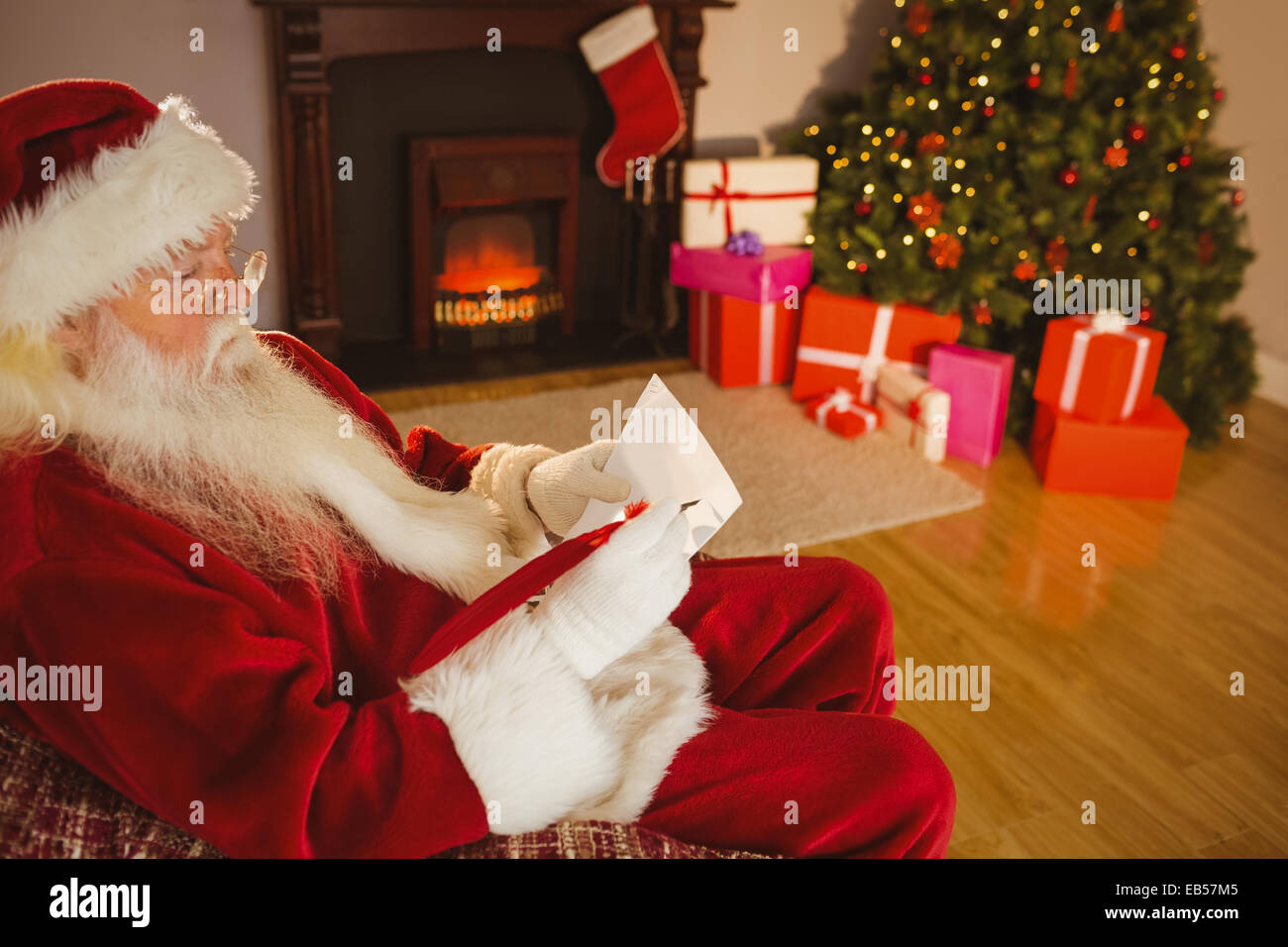 Concentrated santa writing list on scroll Stock Photo - Alamy