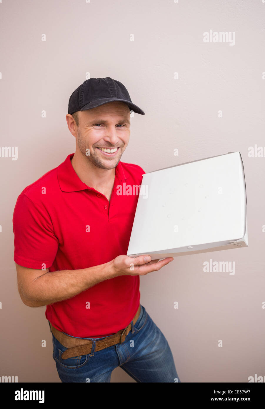 Happy delivery man holding pizza Stock Photo - Alamy
