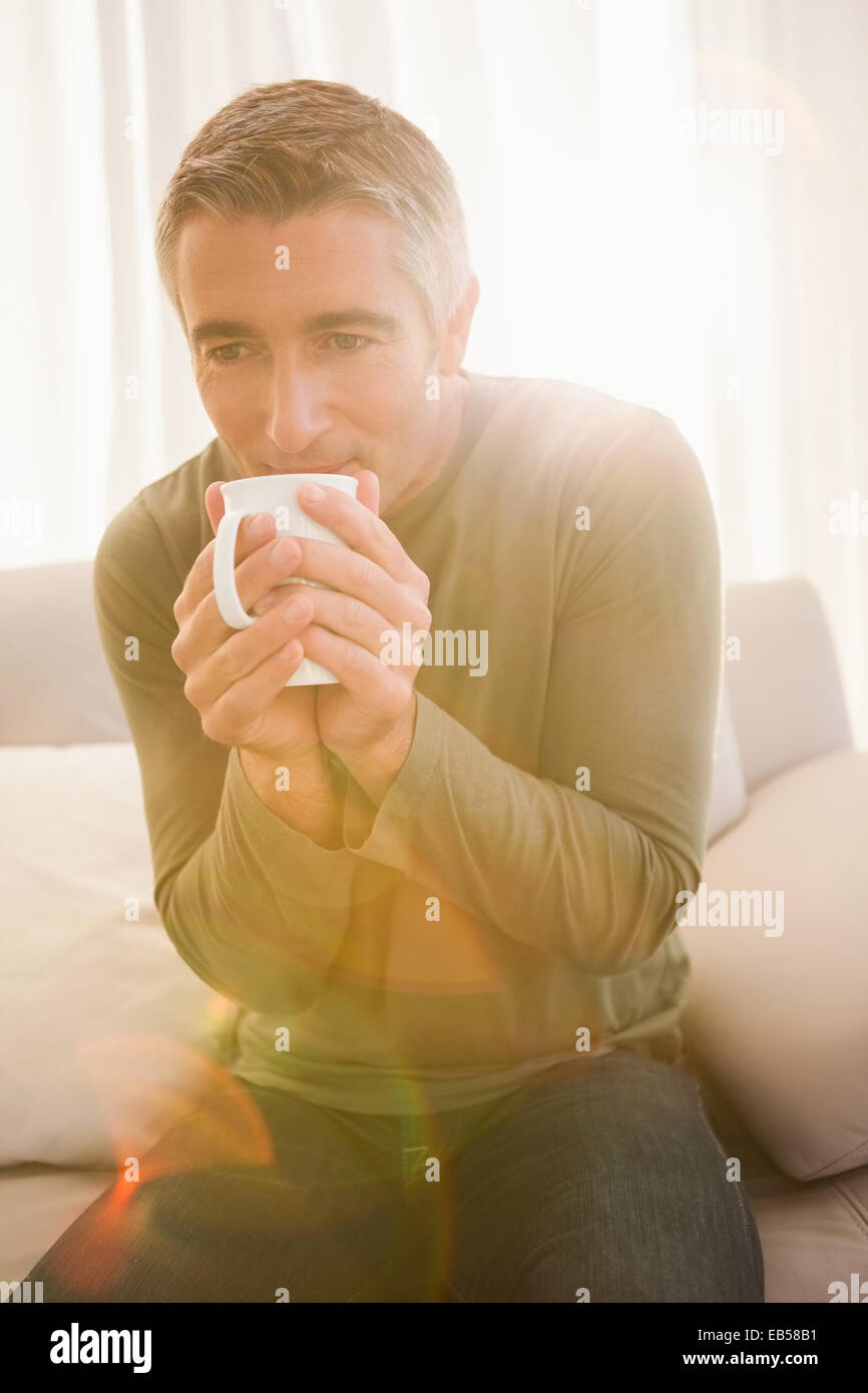 Smiling man drinking hot beverage Stock Photo - Alamy