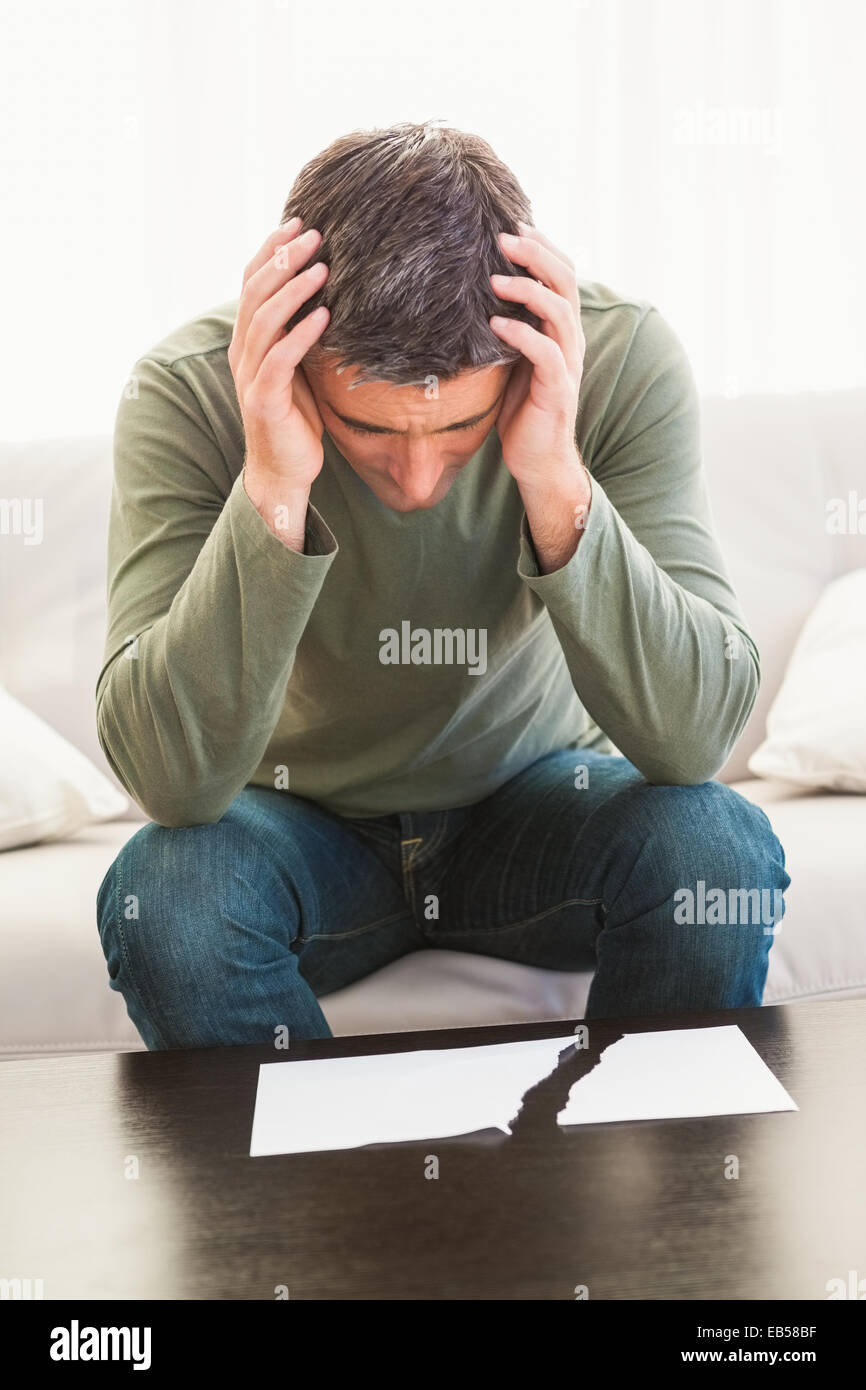 Sad man with hands on his head looking ripped paper Stock Photo - Alamy