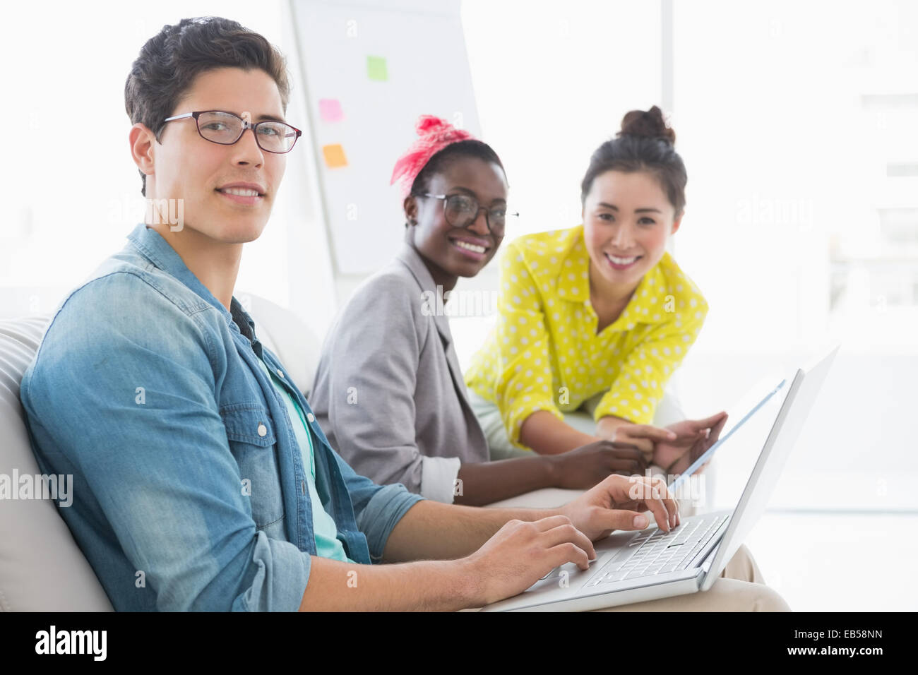 Young creative team working on couch Stock Photo - Alamy