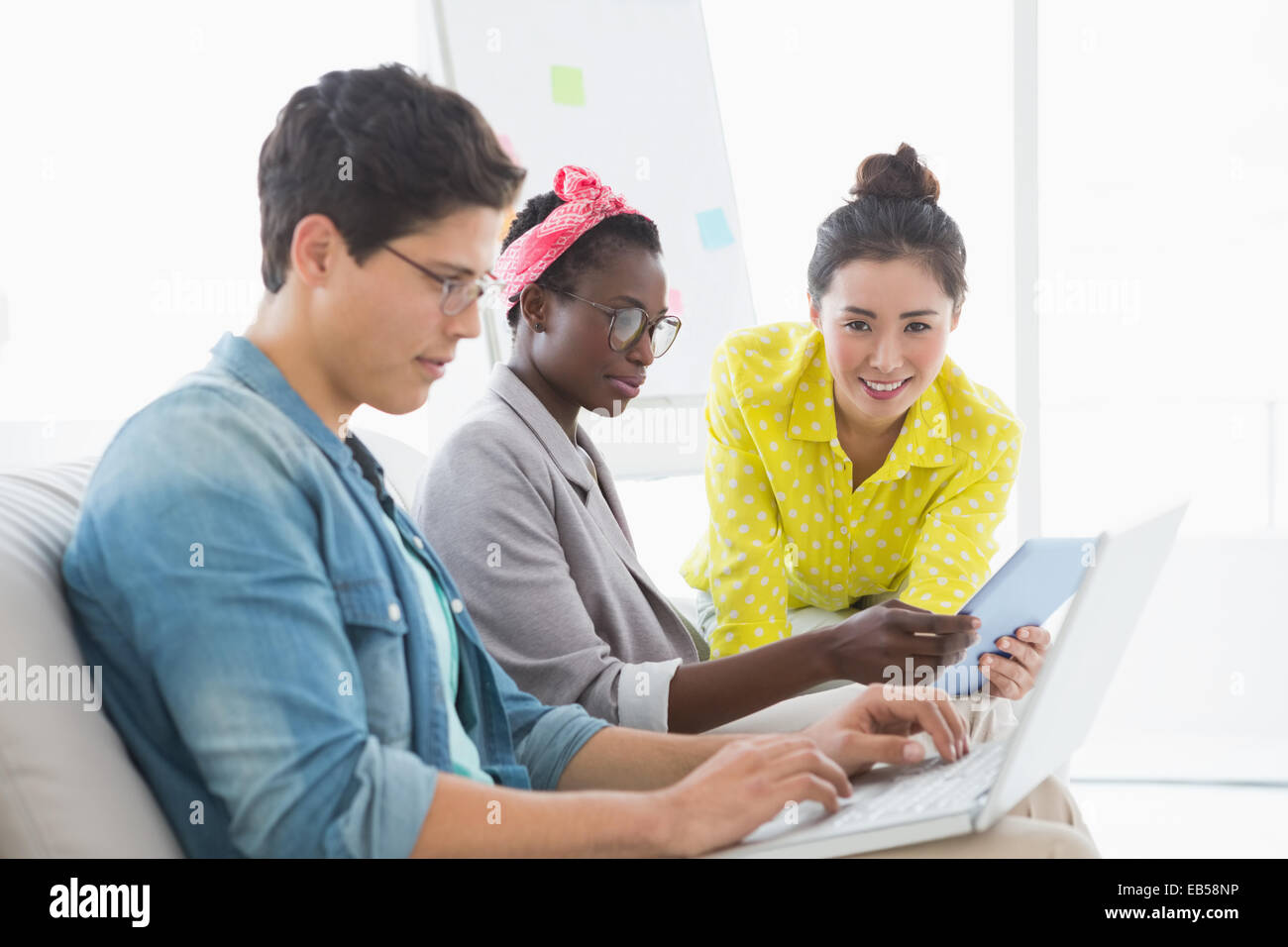 Young creative team working on couch Stock Photo - Alamy