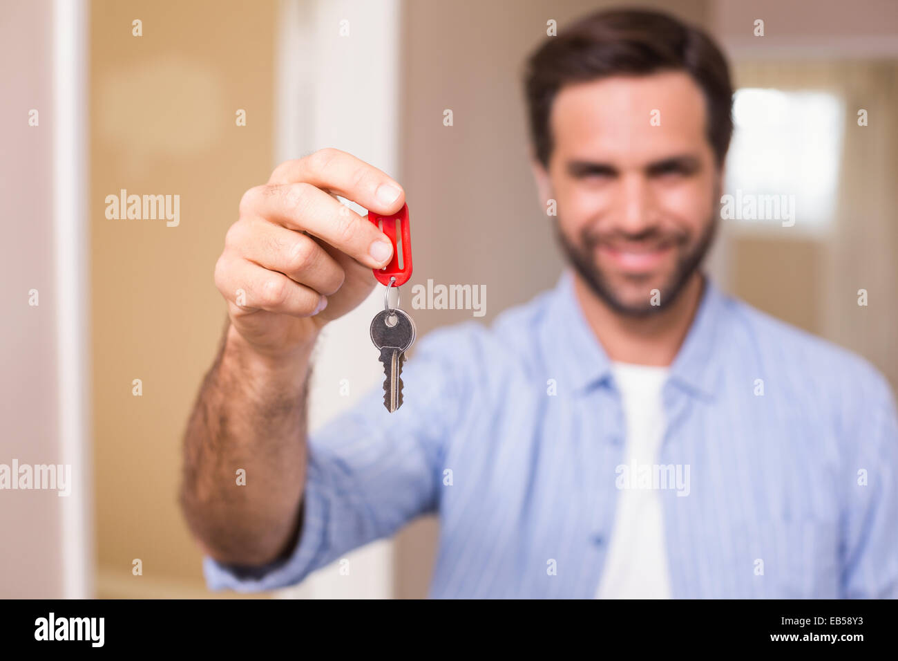 Casual man showing his house key Stock Photo - Alamy
