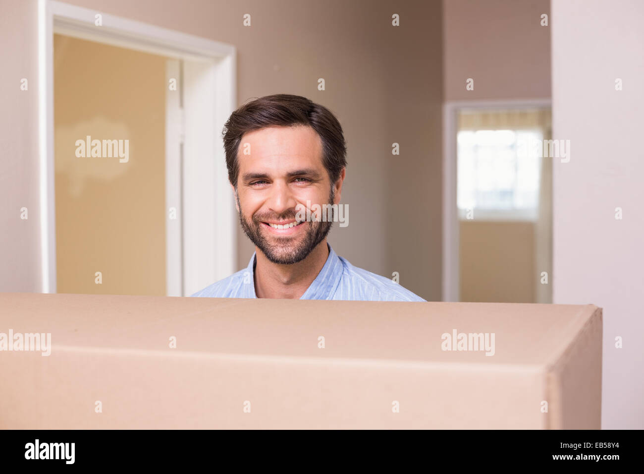 Happy man carrying moving box Stock Photo - Alamy