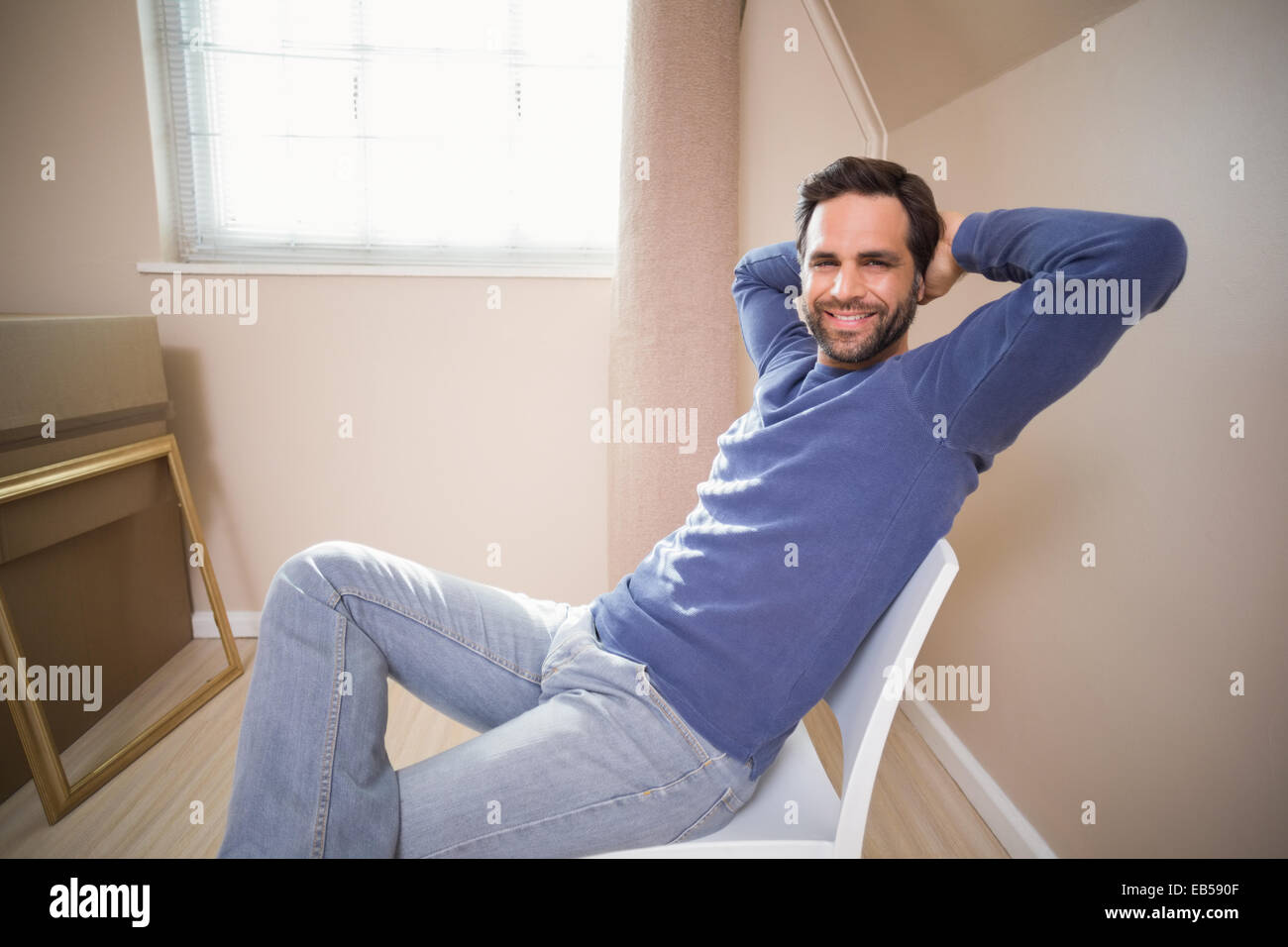 Happy man sitting back after moving in Stock Photo - Alamy