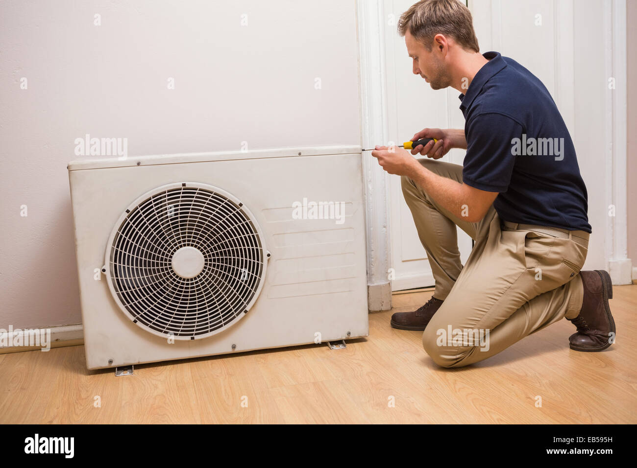 Focused handyman fixing air conditioning Stock Photo - Alamy