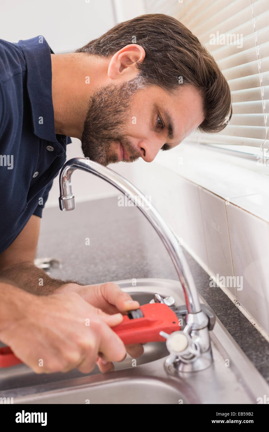 Man fixing tap with tool Stock Photo - Alamy