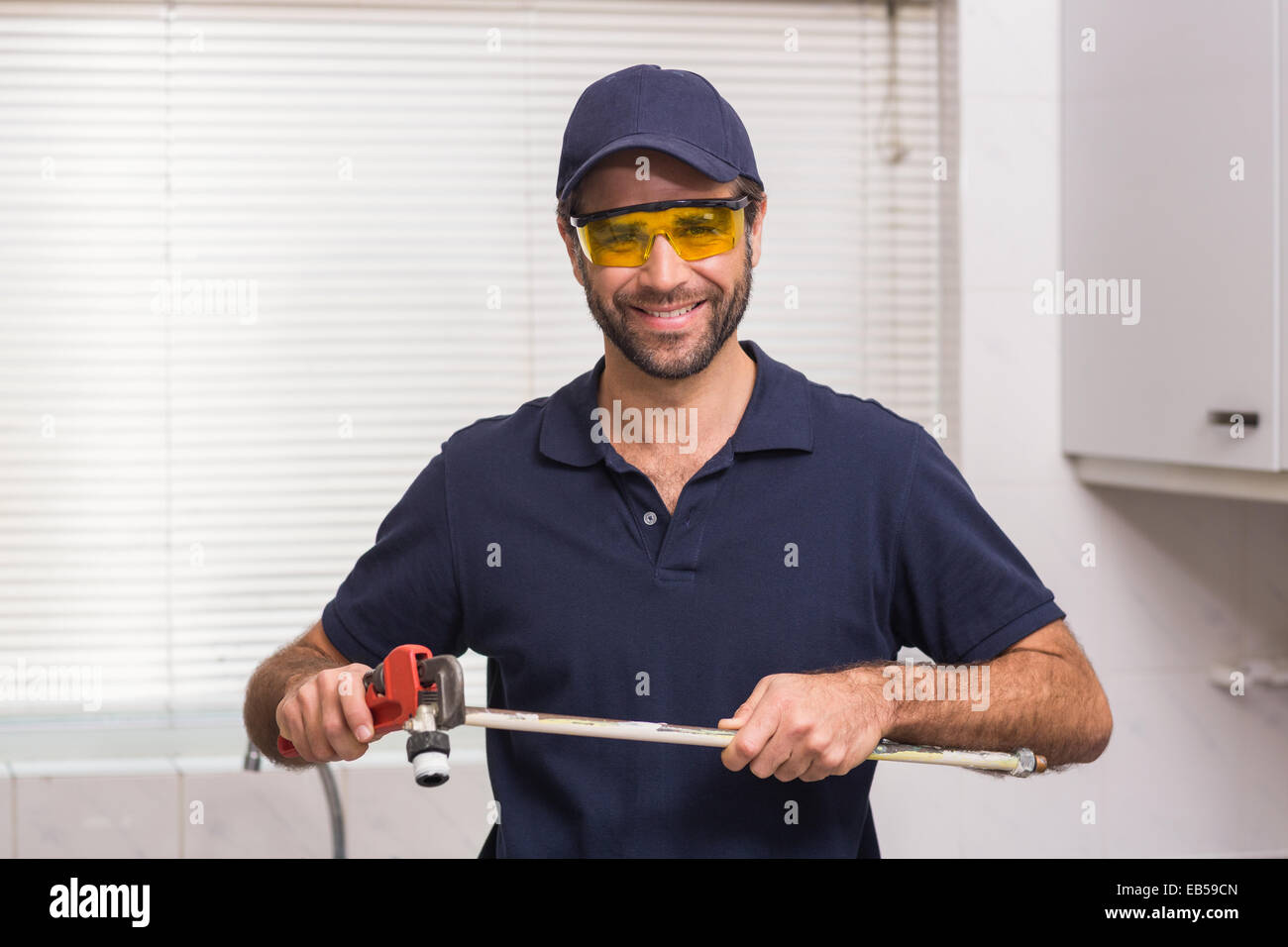 Plumber fixing pipe with wrench Stock Photo - Alamy