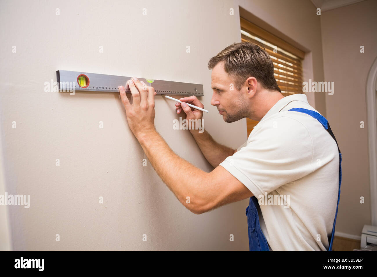 Construction worker using spirit level Stock Photo - Alamy