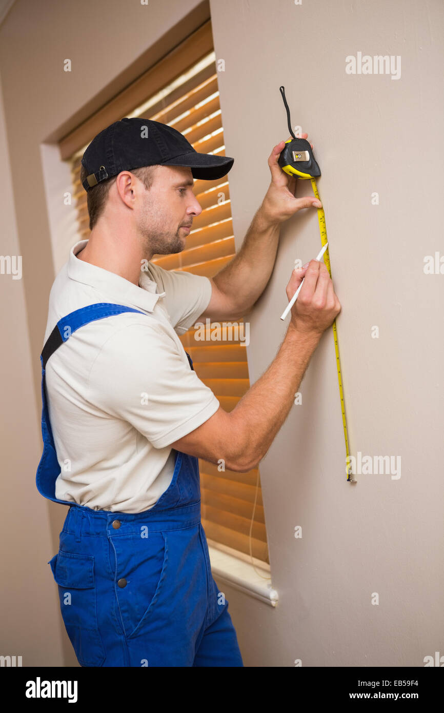 Construction worker using measuring tape Stock Photo - Alamy