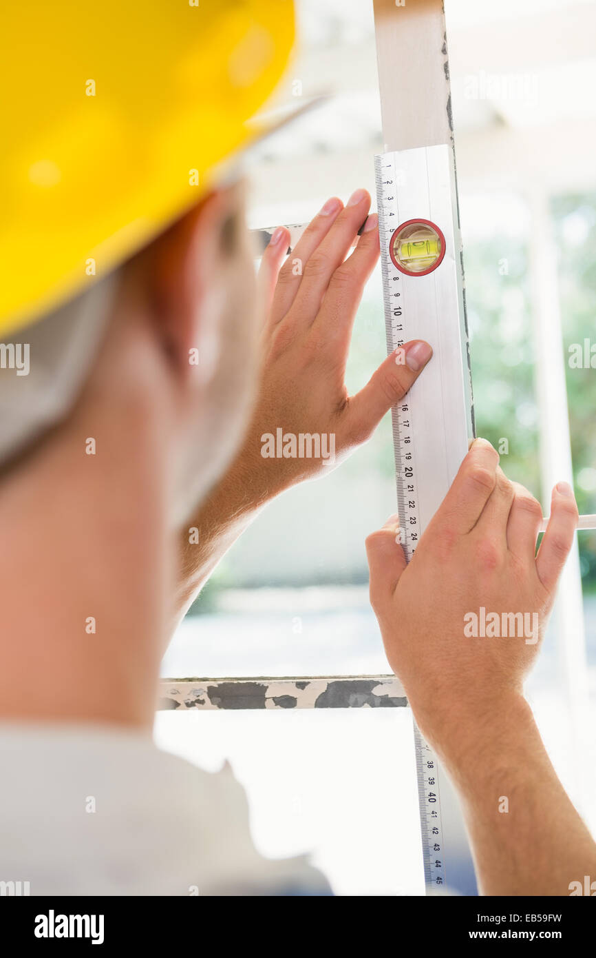 Construction worker using spirit level Stock Photo - Alamy