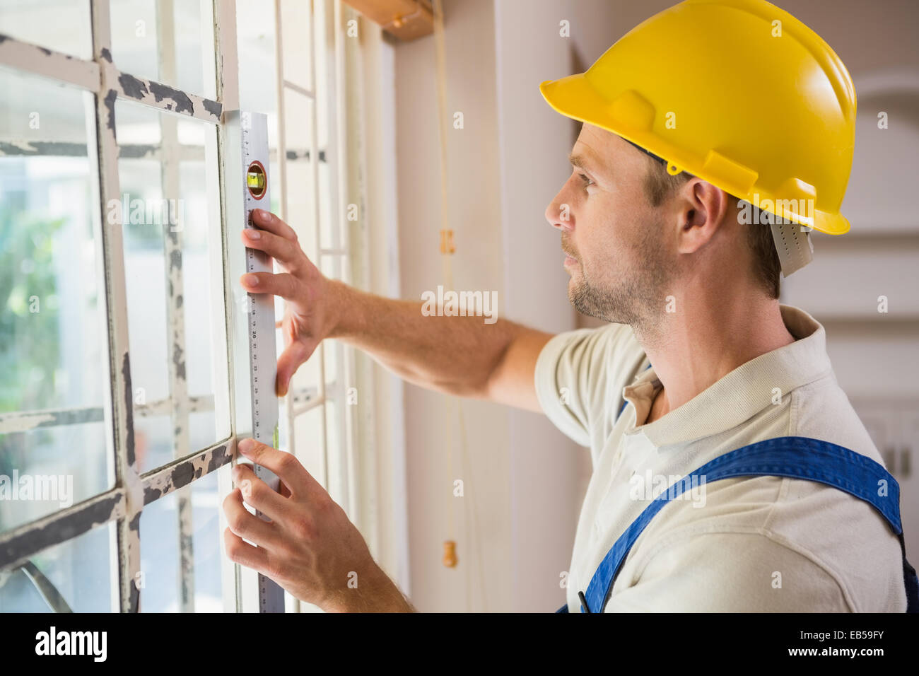 Construction worker using spirit level Stock Photo - Alamy
