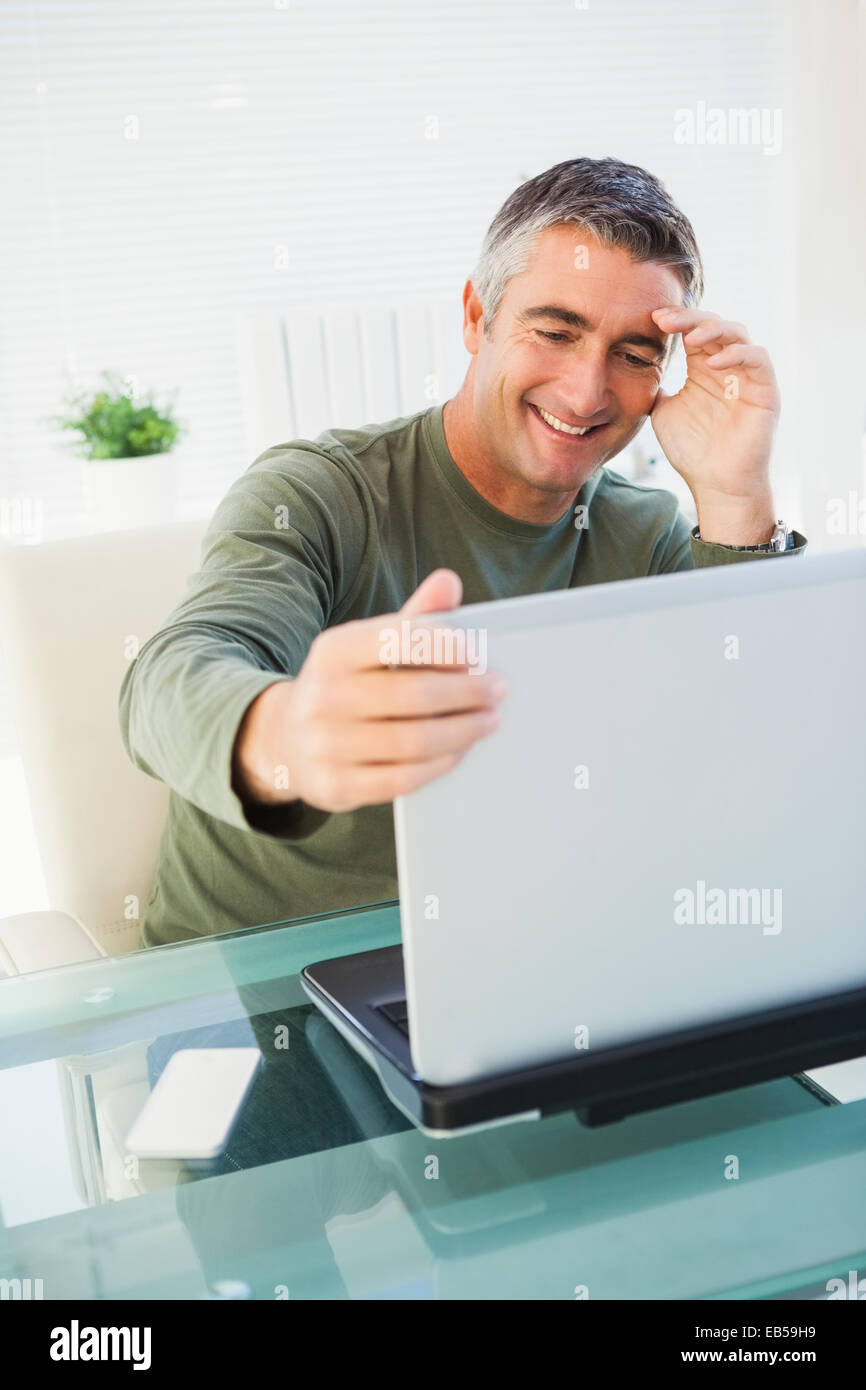 Cheerful man sitting and holding his laptop Stock Photo - Alamy