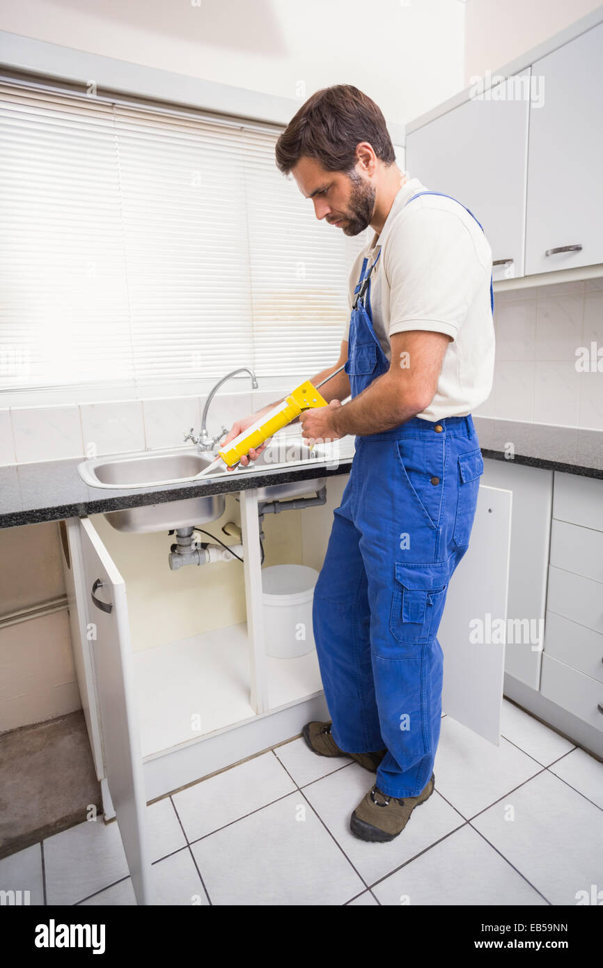 Plumber putting filling in between tiles Stock Photo - Alamy