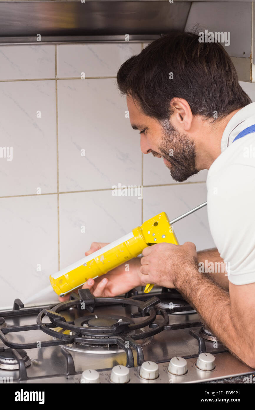 Plumber putting filling in between tiles Stock Photo - Alamy