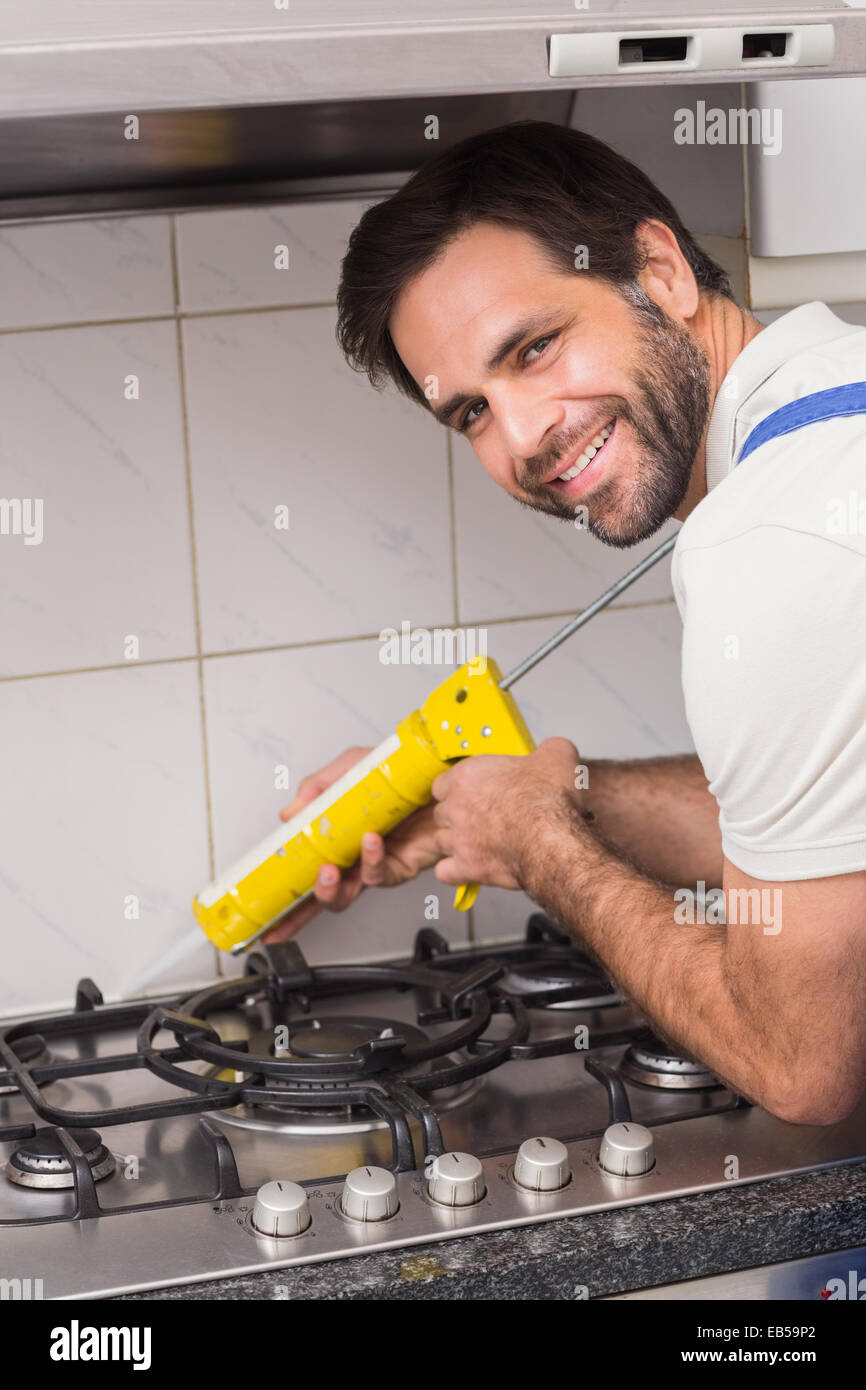 Plumber putting filling in between tiles Stock Photo - Alamy
