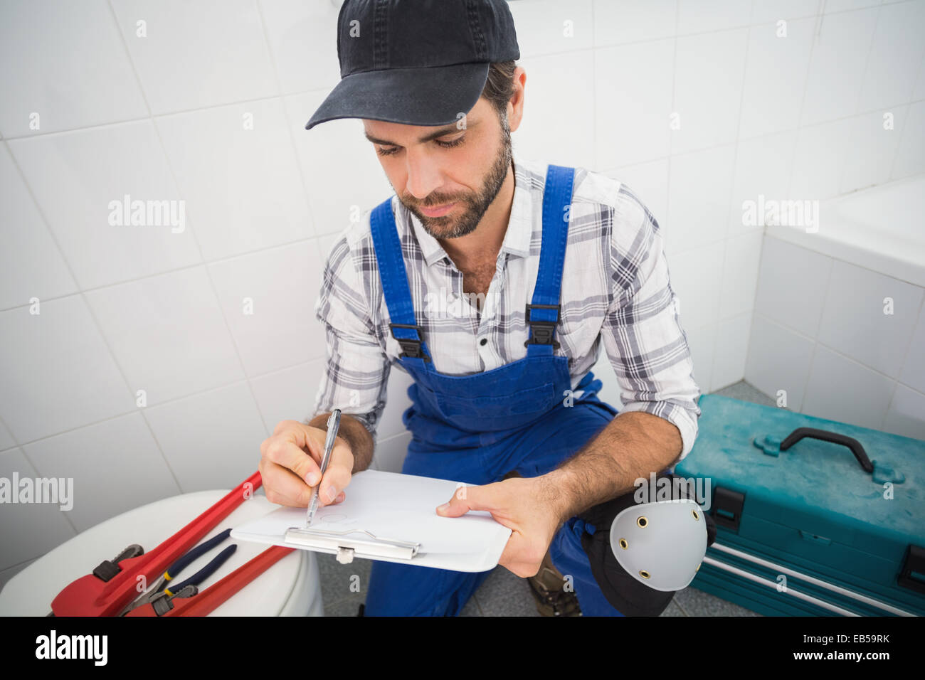 Plumber taking notes on clipboard Stock Photo - Alamy