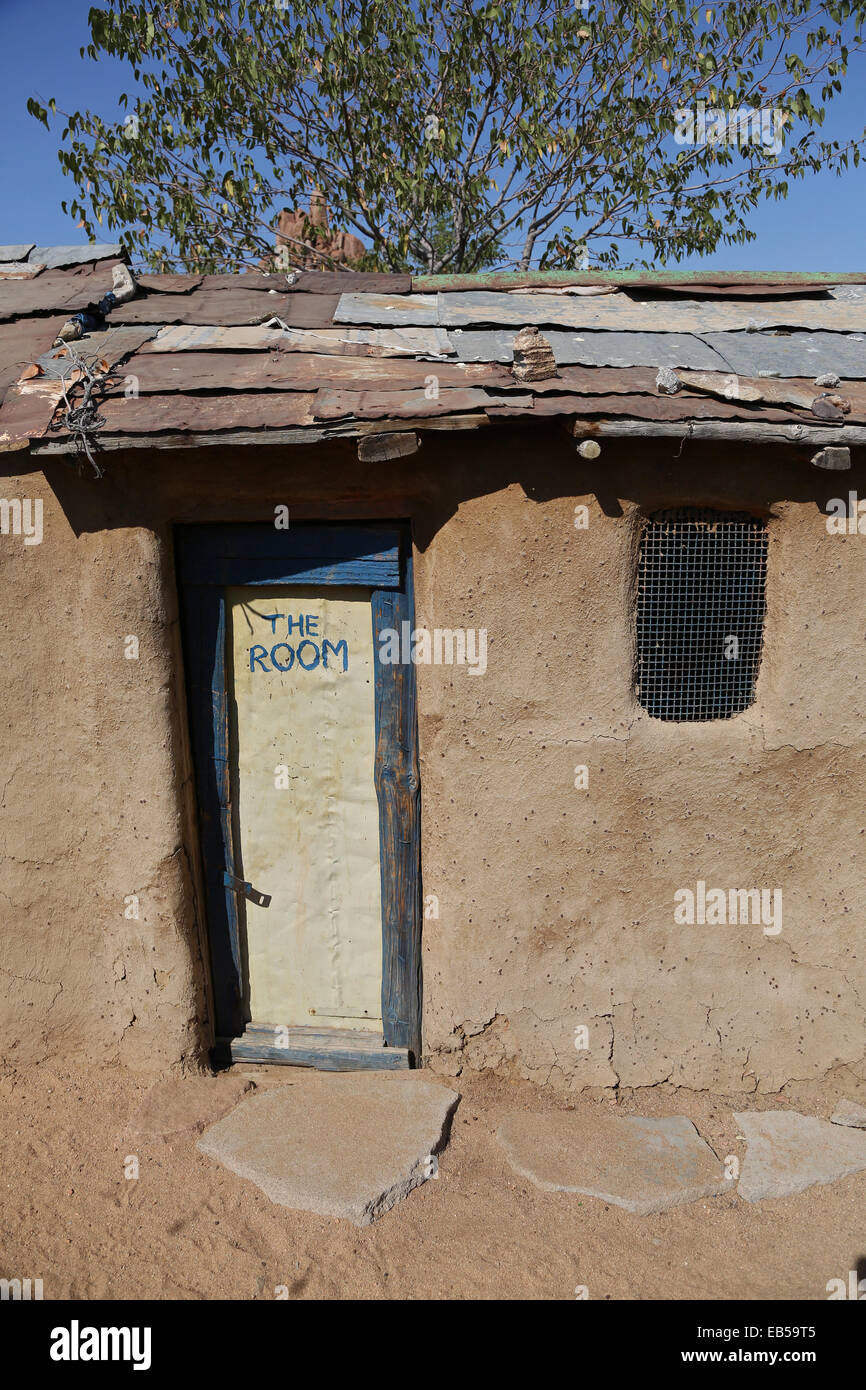 The Room, sign painted on door of mud hut on Namibian farm building ...