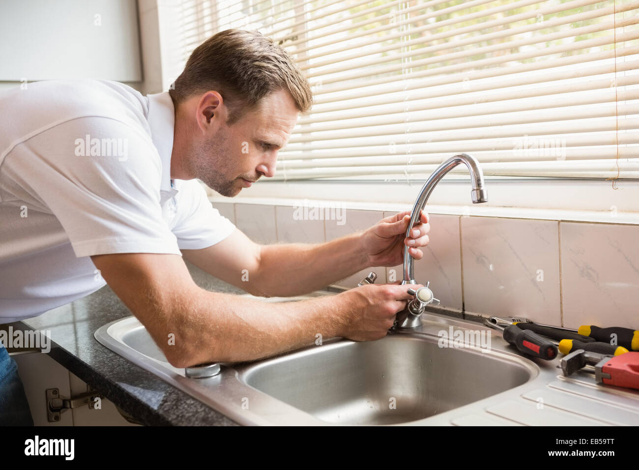 Man fixing tap with pliers Stock Photo - Alamy