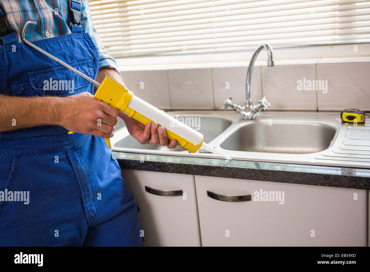 Plumber putting filling in between tiles Stock Photo - Alamy