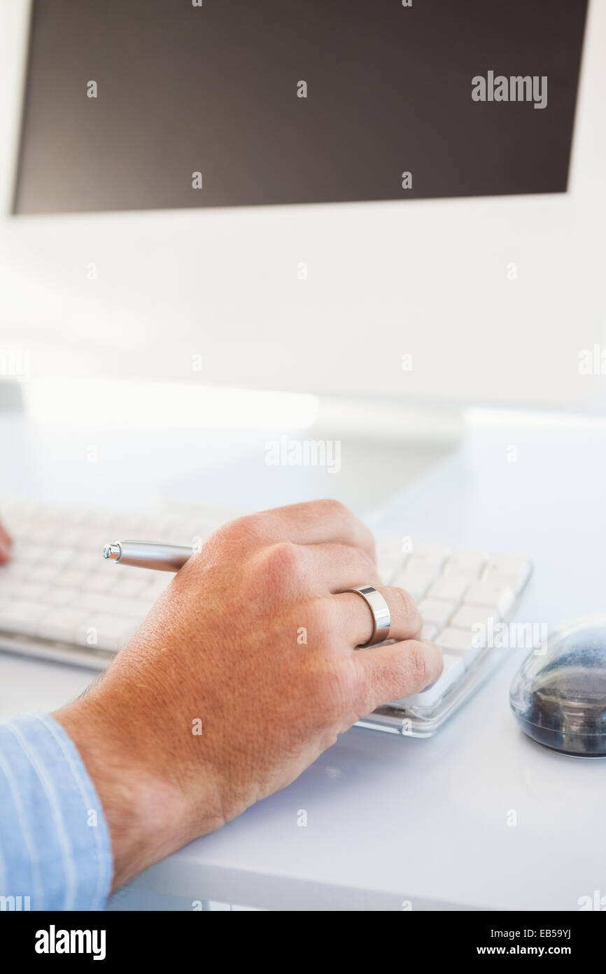 Close up of a hand holding pencil and typing on keyboard Stock Photo ...