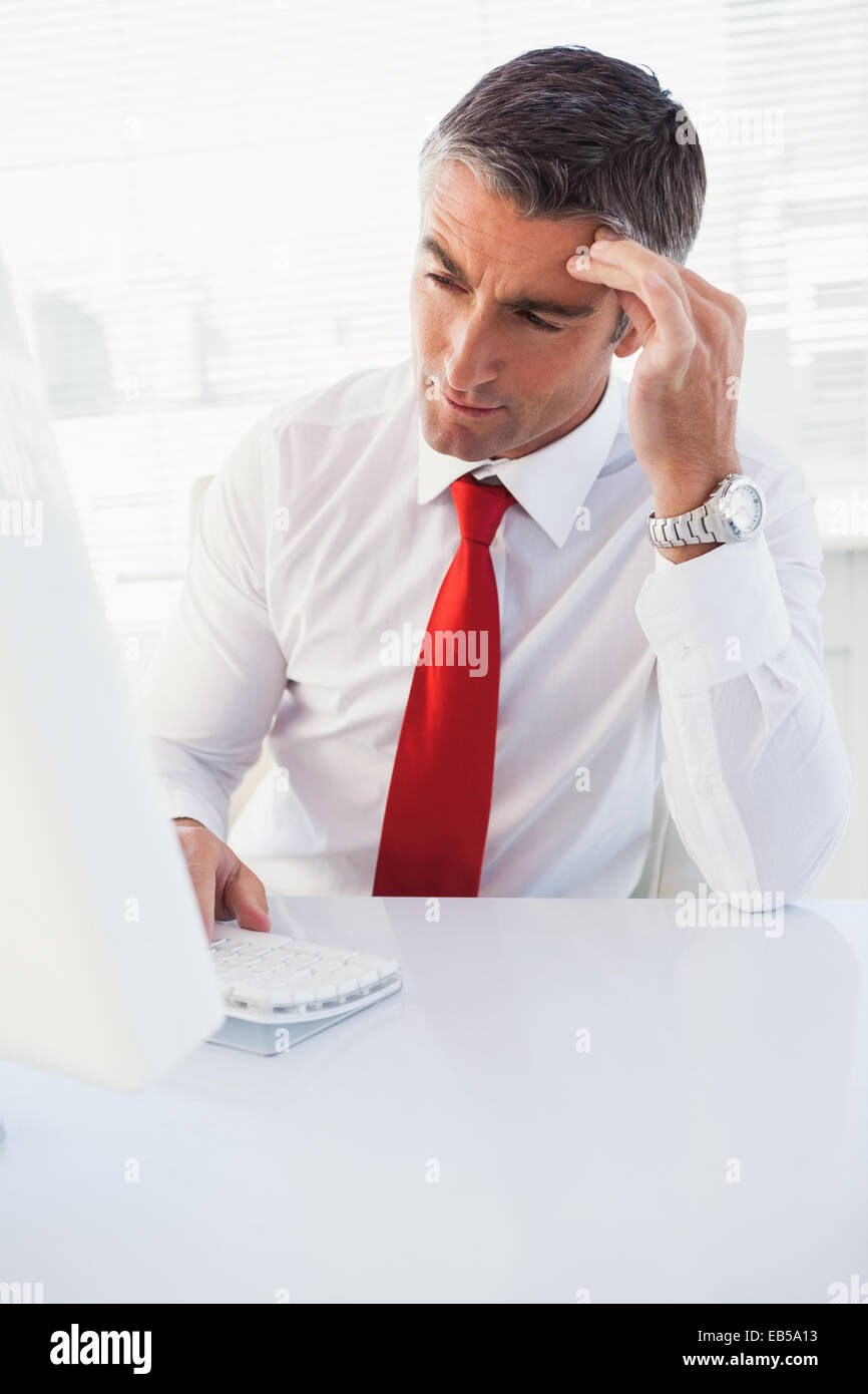 Concentrated businessman using computer and thinking Stock Photo - Alamy