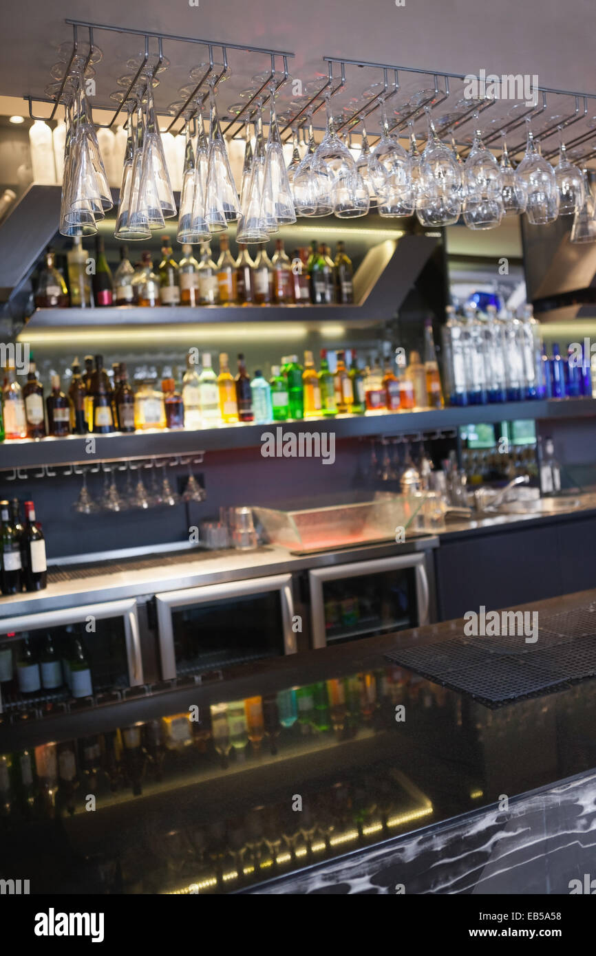 Close up on bar with wine glasses hanging above it Stock Photo - Alamy