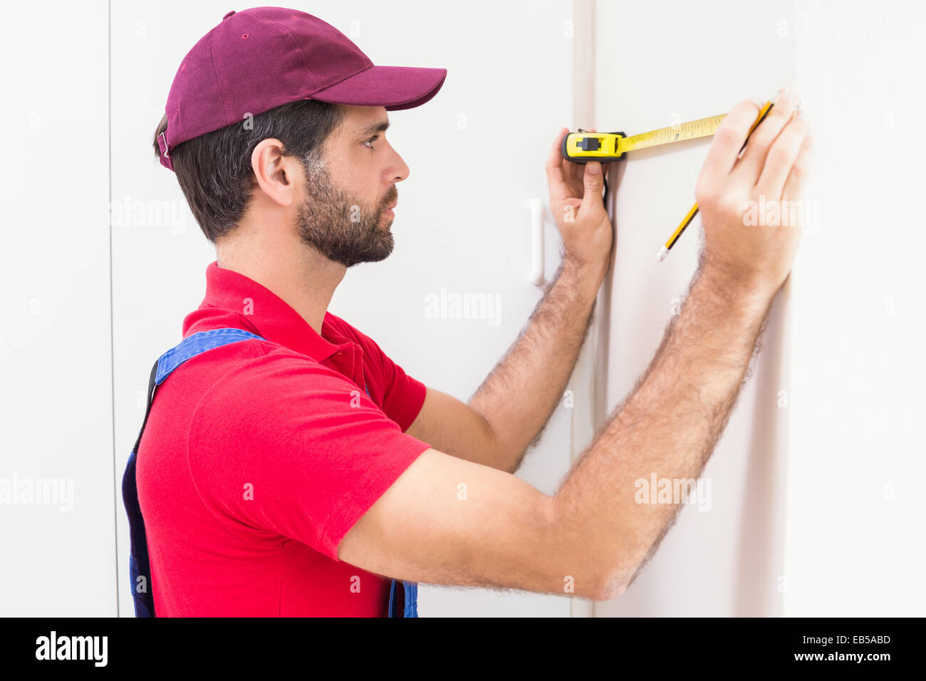 Construction worker using measuring tape Stock Photo - Alamy