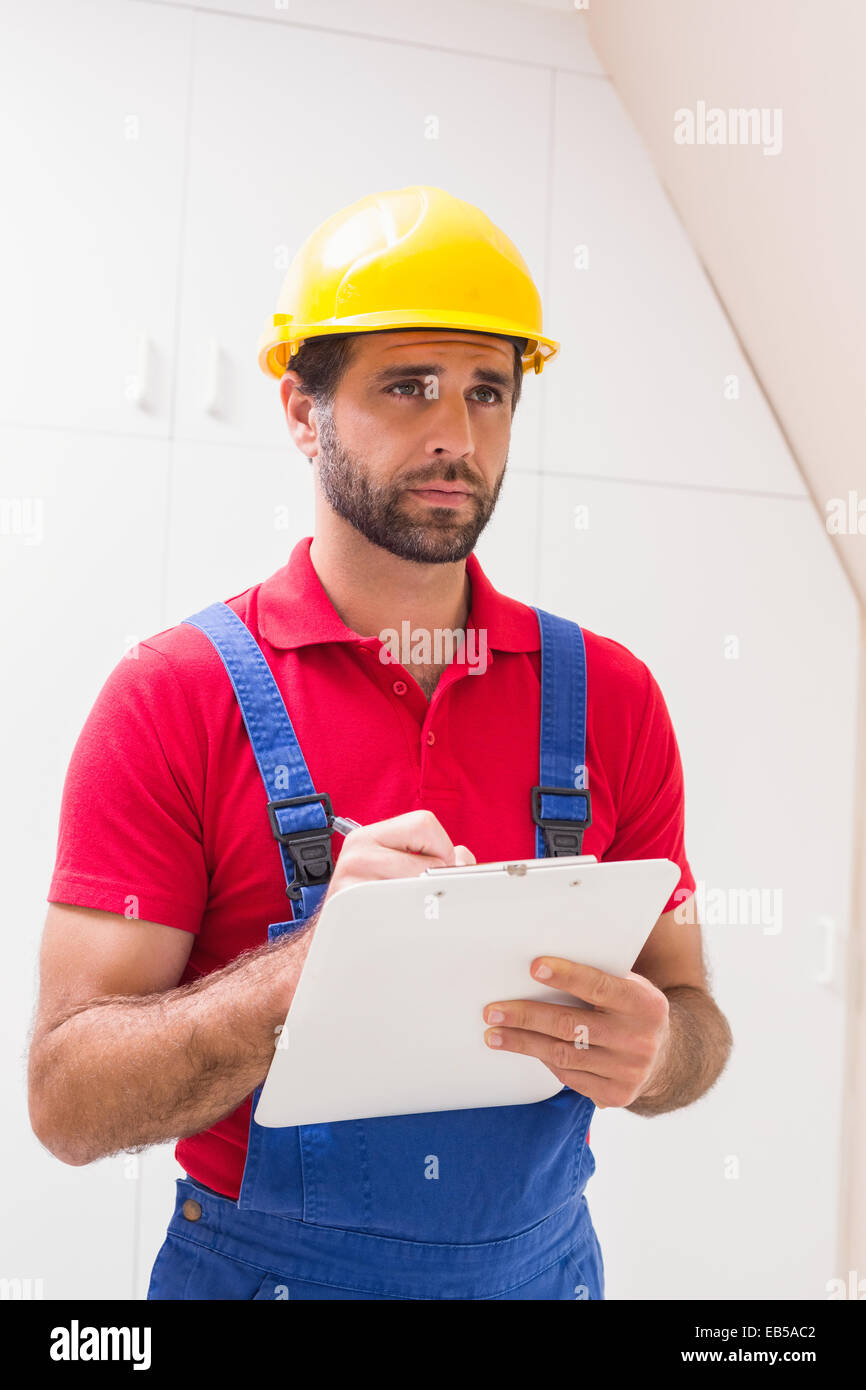 Construction worker taking notes on clipboard Stock Photo - Alamy