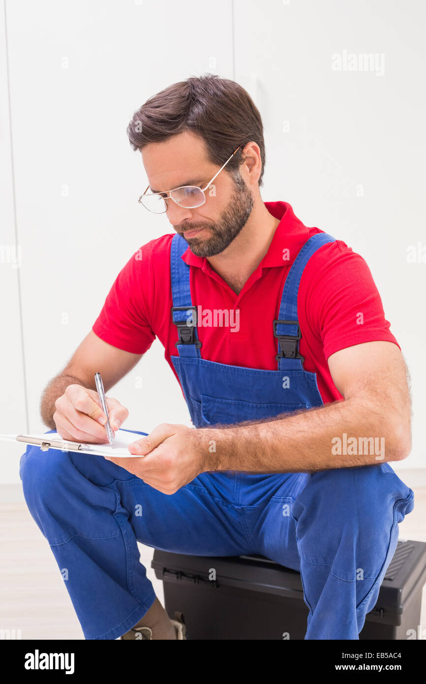 Construction worker taking notes on clipboard Stock Photo - Alamy