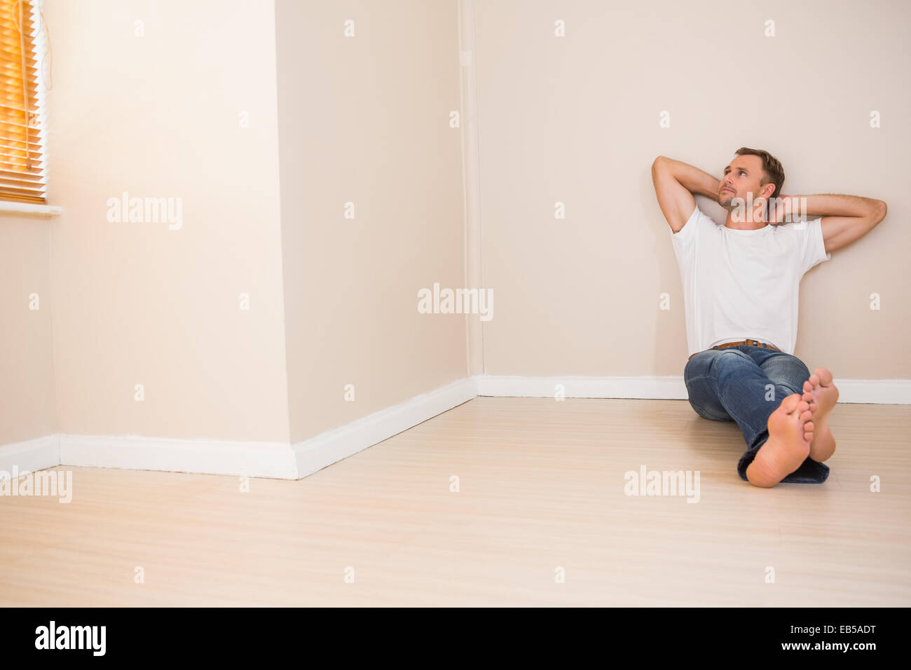 Happy man sitting on floor Stock Photo - Alamy