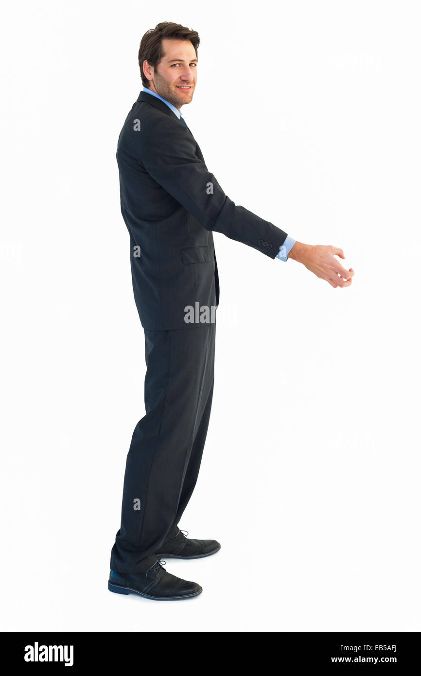Smiling businessman reaching out to shake hands Stock Photo - Alamy