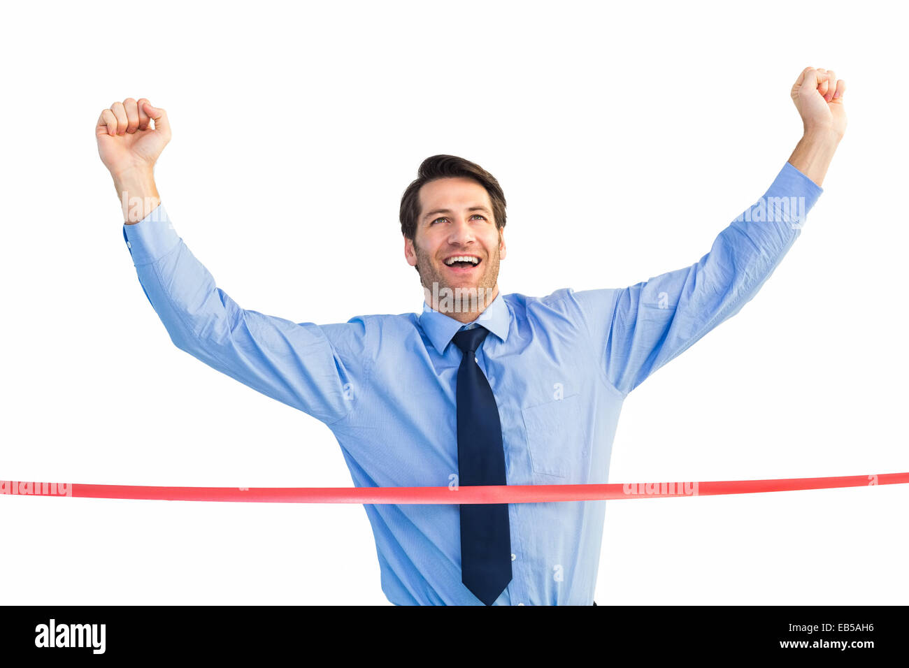 Happy businessman crossing finishing line Stock Photo - Alamy
