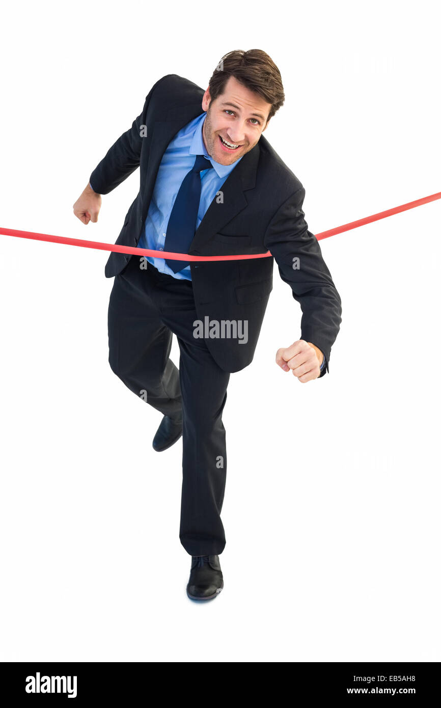 Happy businessman crossing finishing line Stock Photo - Alamy