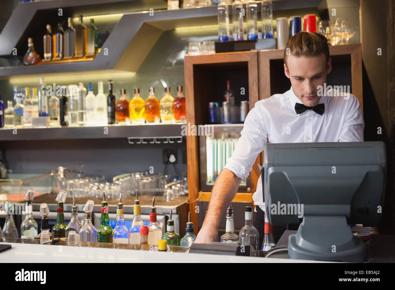 Handsome barman standing at the cash register Stock Photo - Alamy