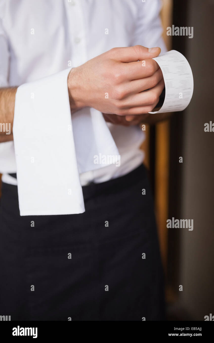 Handsome waiter reading a receipt Stock Photo - Alamy