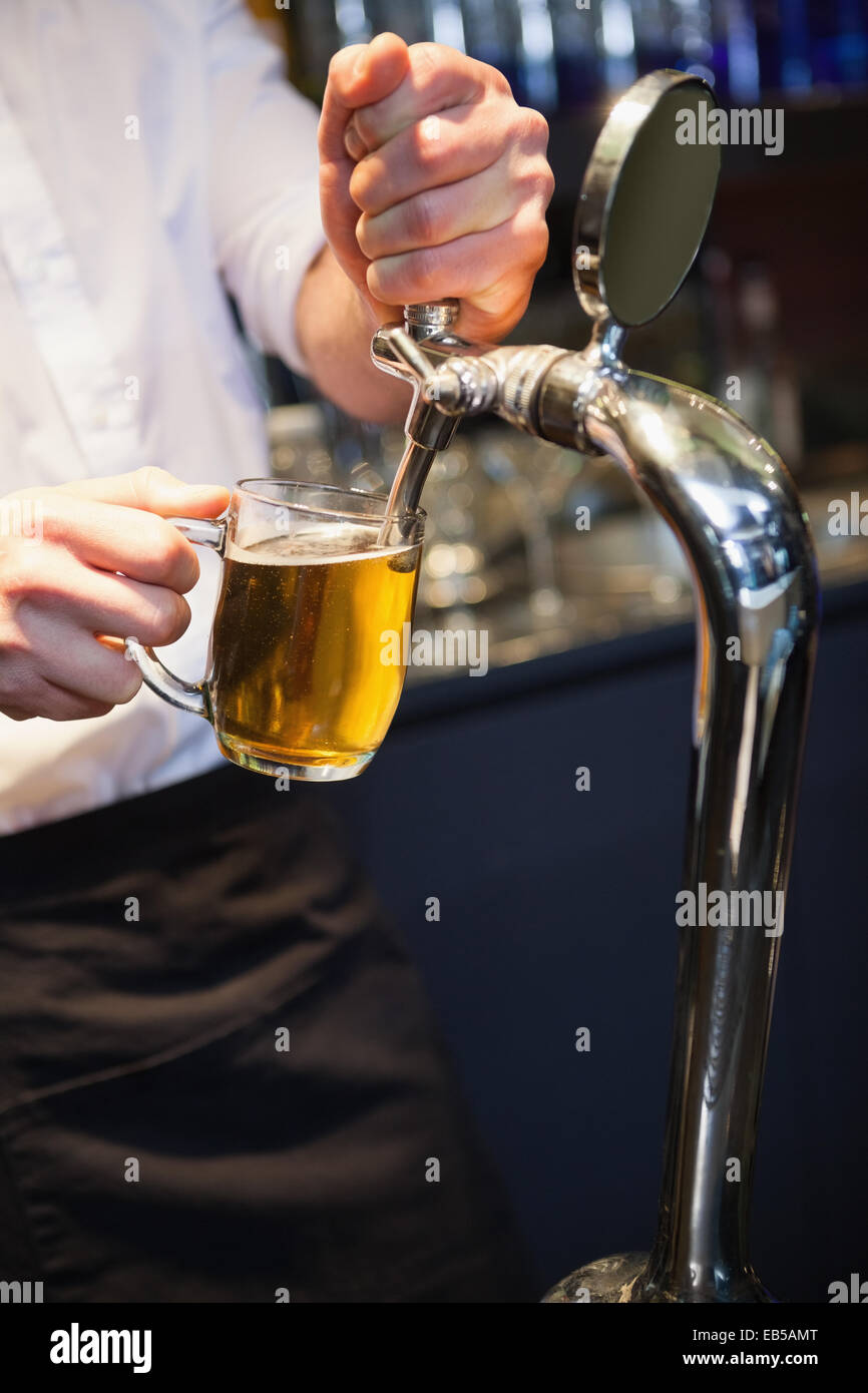 Handsome barkeeper pulling a pint of beer Stock Photo - Alamy
