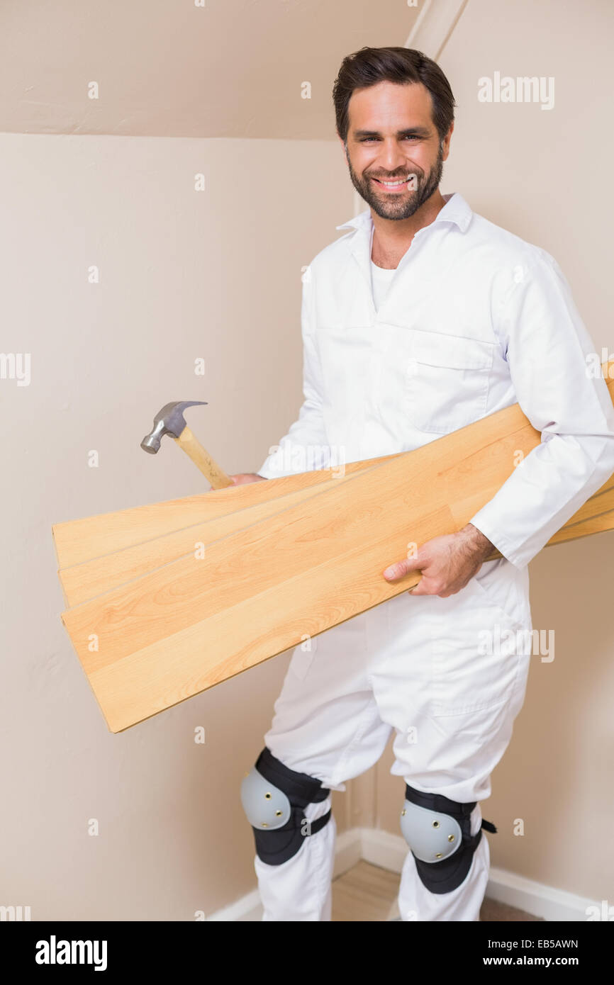 Carpenter holding planks and hammer Stock Photo - Alamy