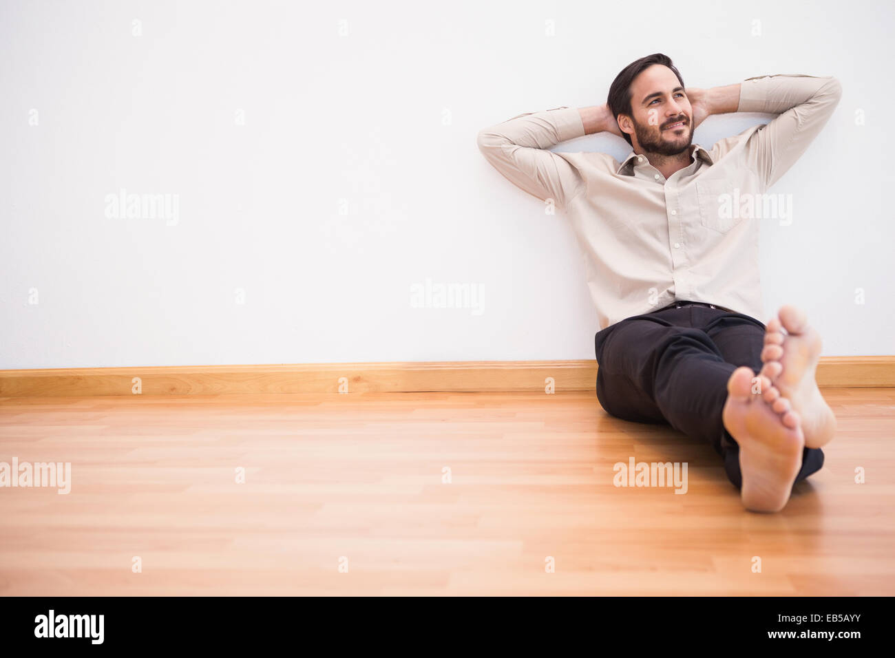 Thoughtful man leaning against wall with crossed arms Stock Photo - Alamy