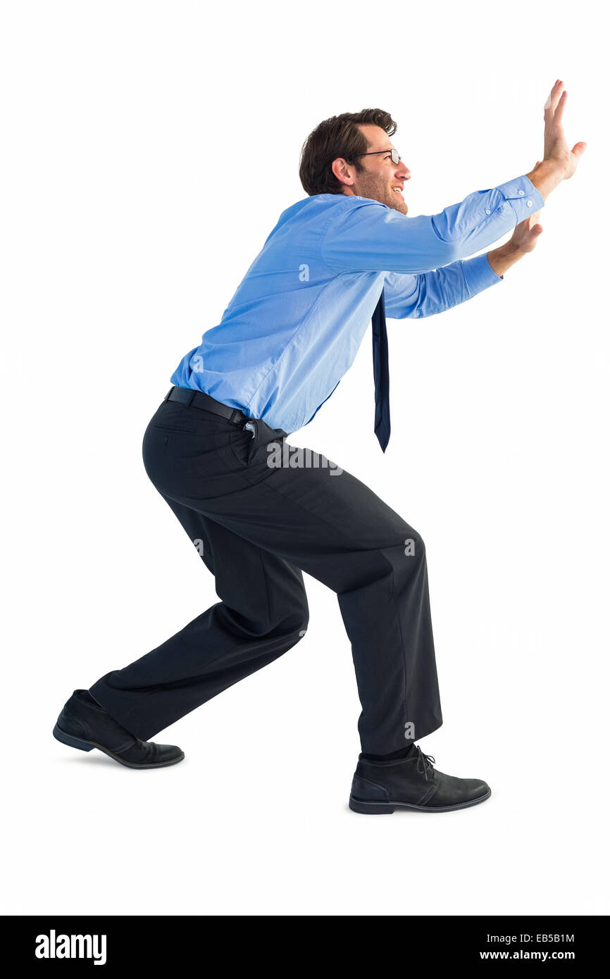 Businessman standing with bent legs and pushing Stock Photo - Alamy