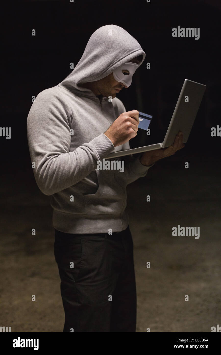 Hacker using laptop to steal identity Stock Photo - Alamy