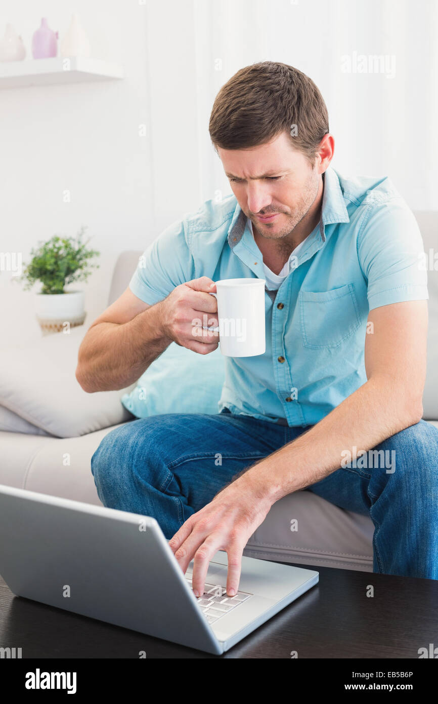 Concentrate man using his laptop at home Stock Photo - Alamy