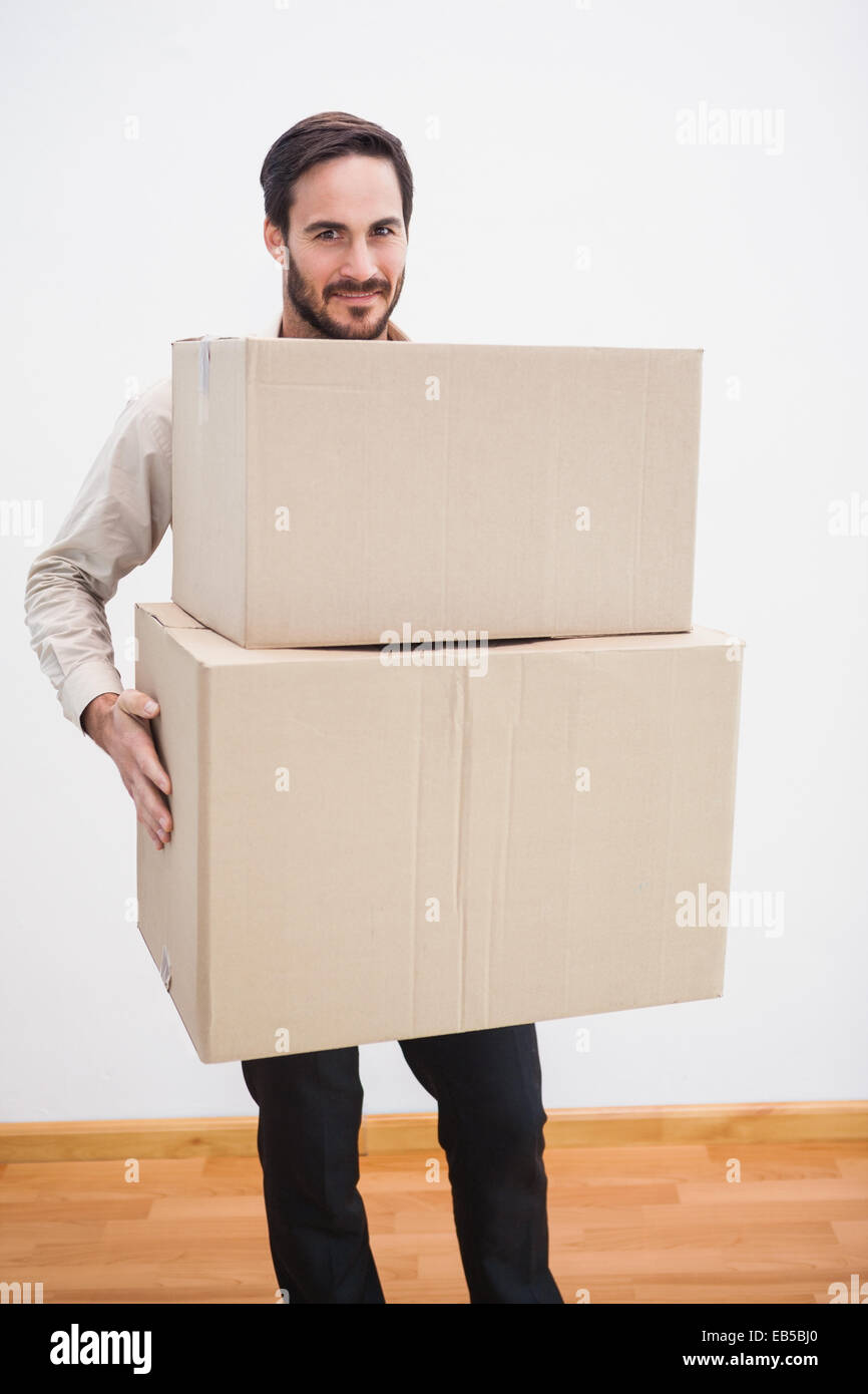 Smiling man holding a cardboard moving box Stock Photo - Alamy