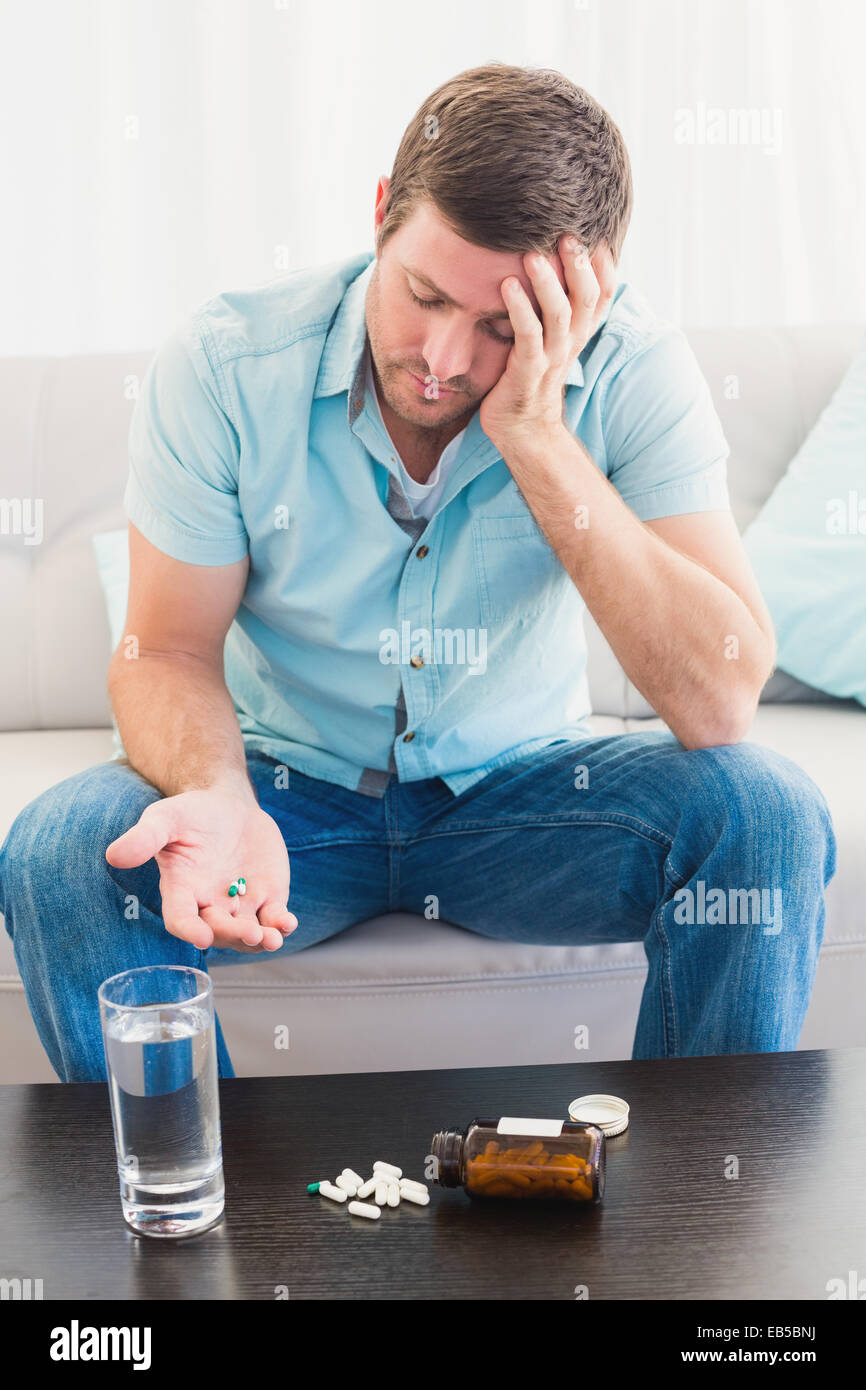 Hungover man with his medicine laid out on coffee table Stock Photo - Alamy