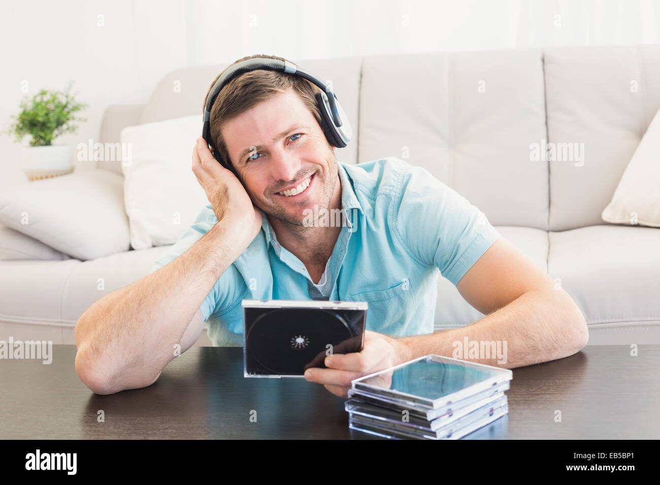 Smiling man listening to cds Stock Photo - Alamy